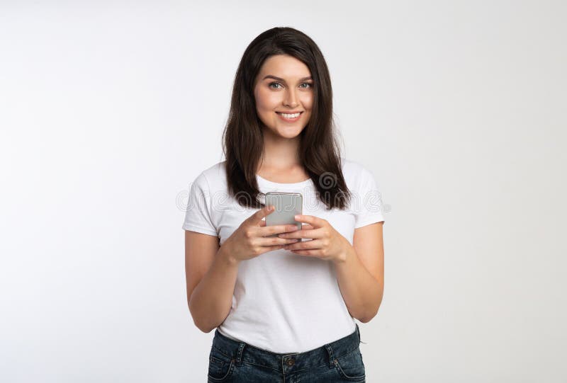 Smiling Young Lady Using Mobile Phone Standing in Studio Stock Image ...