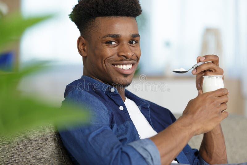 Smiling Young Man Eating Yogurt Stock Photo - Image of snack, smile ...