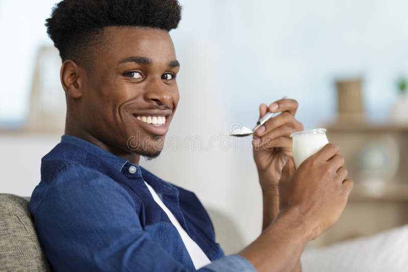 Smiling Young Man Eating Yogurt Stock Image - Image of spoon, healthy ...