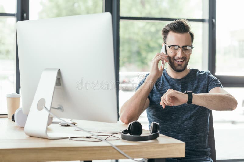 Smiling Young Man in Eyeglasses Checking Smartwatch and Talking by ...