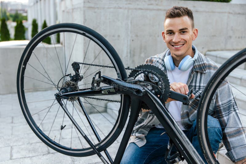 Smiling Young Man Fixing a Problem with a Bike Wheel Stock Image ...