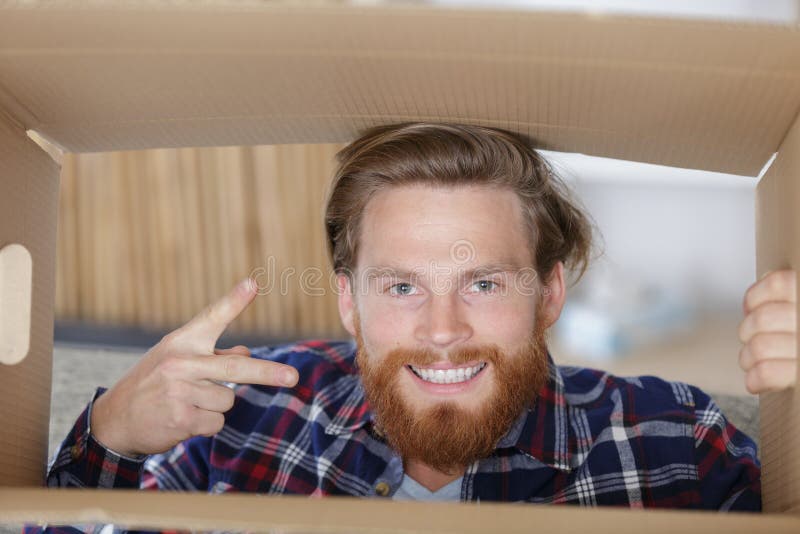 Smiling Young Man Looking into Cardboard Box Stock Photo - Image of ...