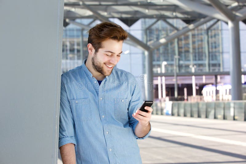 Smiling Young Man Looking at Mobile Phone Stock Image - Image of beard ...