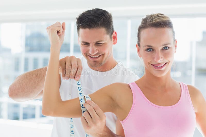 Smiling Young Man Measuring Womans Arm Stock Photo - Image of body ...