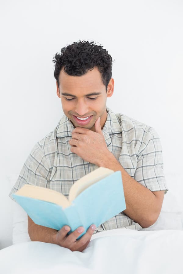Smiling Young Man Reading Book in Bed Stock Image - Image of casual ...