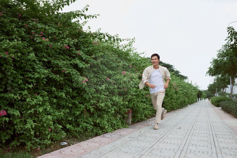 Smiling Young Man Running in the Park during Summer Stock Photo - Image ...