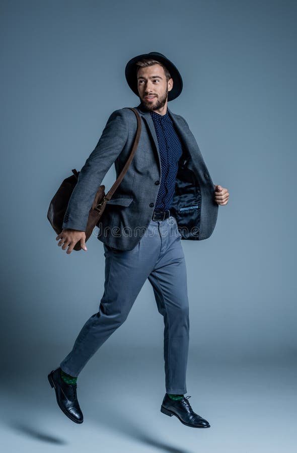 Smiling Young Man in Suit and Hat Jumping Up with Leather Bag Stock ...