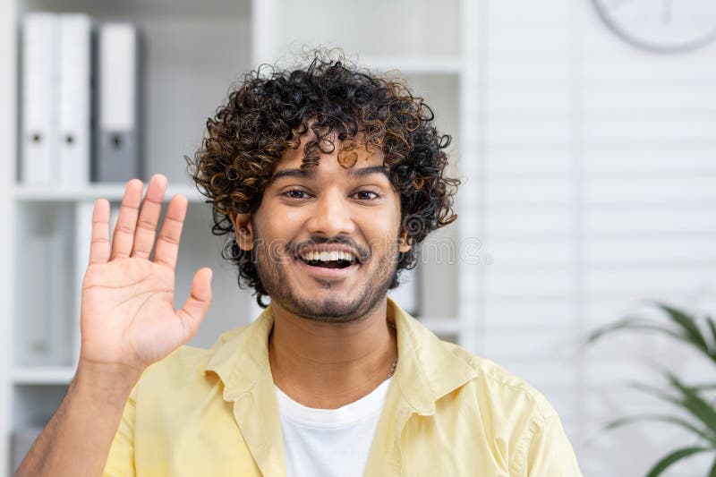 Smiling Young Man Waving during a Video Call at Home Office Stock Photo ...