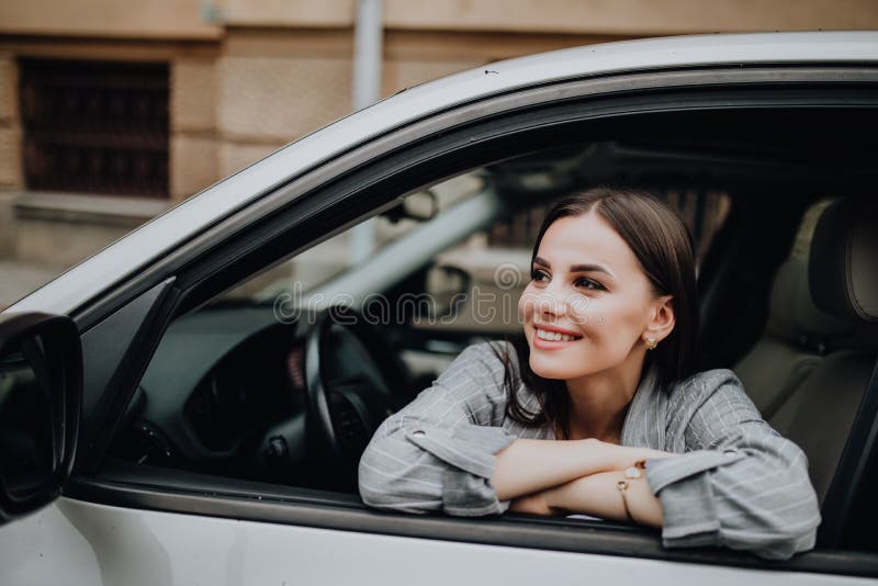 Smiling Young Pretty Woman in the Car Lying on the Window. Stock Photo ...