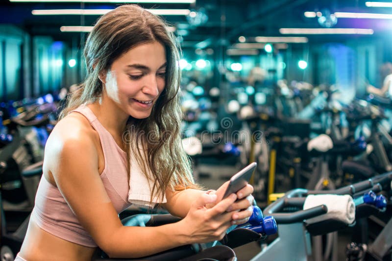 Smiling Young Sportswoman Using Smartphone during Training Break in ...
