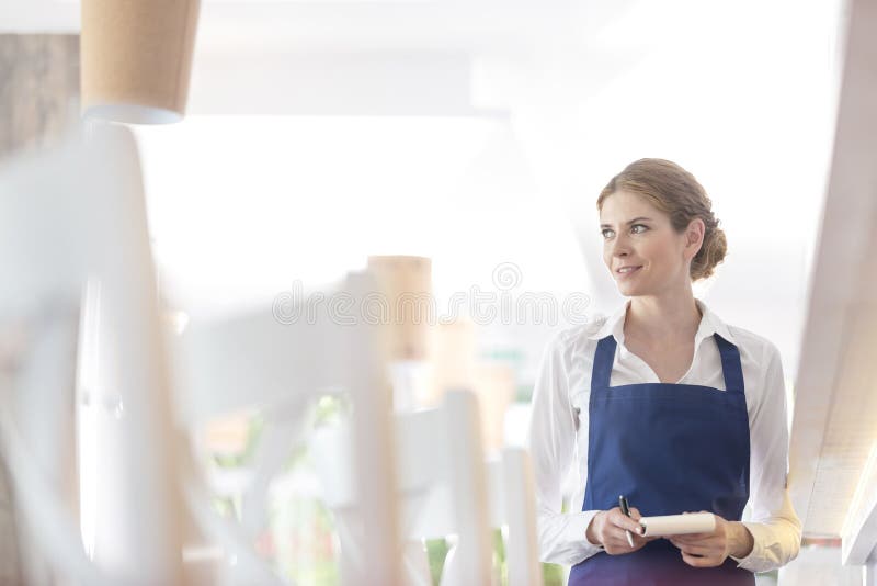 Portrait of Smiling Young Waitress Standing at Counter in Restaurant ...