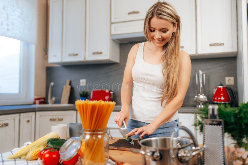 Smiling Young Woman Cooking Something at Her Kitchen Stock Image ...