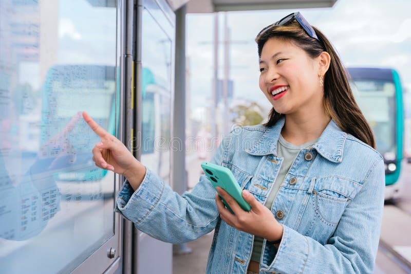 Young Woman Using Ticket Machine at Tram Stop Holding Smartphone Stock Image - Image of digital ...