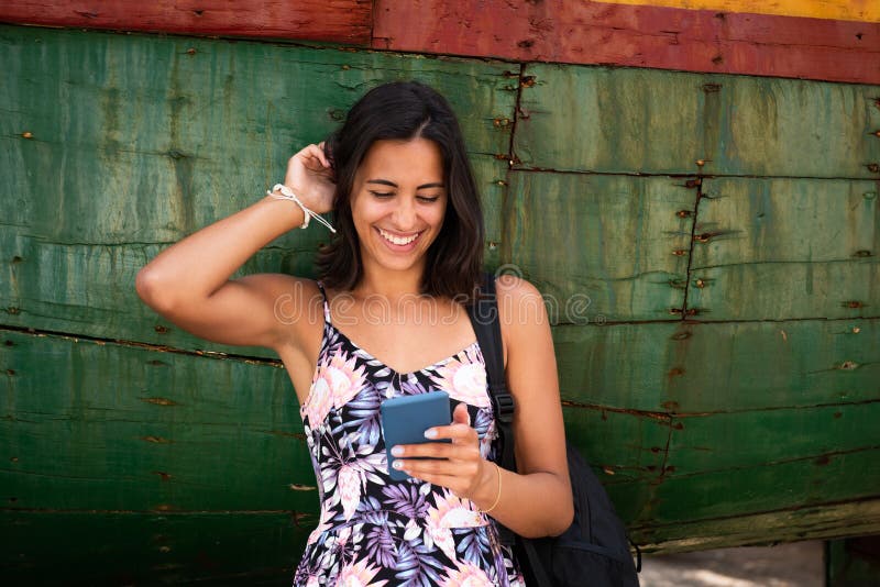 Smiling Young Woman Looking at Cellphone Outside Stock Image - Image of ...