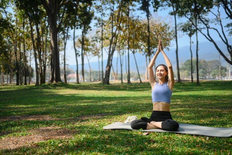 Smiling Young Woman Practicing Yoga Outdoors in Nature Stock Photo ...