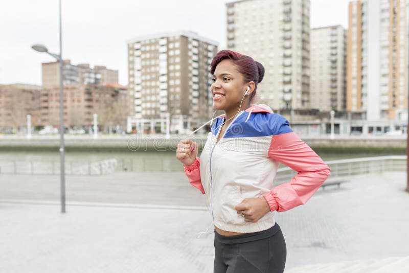 Smiling Young Woman Running in the Street. Stock Photo - Image of ...