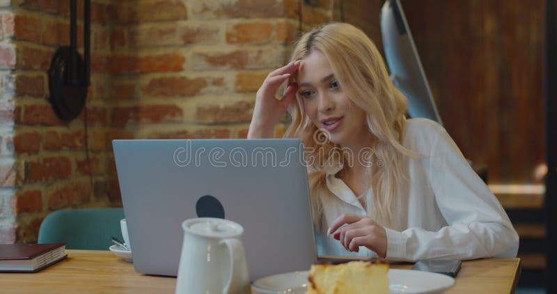A Smiling Young Woman is Talking with Someone Using Her Laptop Computer ...