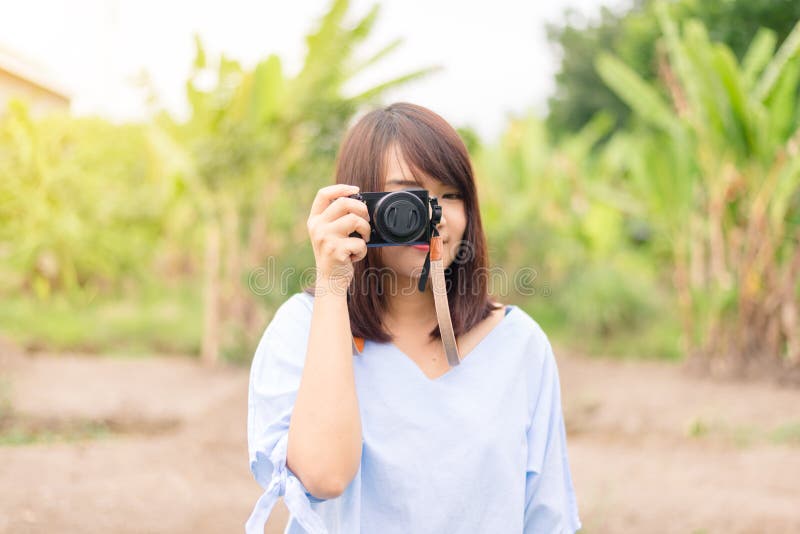 Smiling Young Woman Using Camera To Take Photo Outdoors at the Park ...