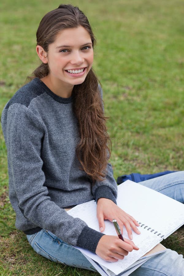 Smiling Young Woman Writing on Her Notebook Stock Image - Image of ...