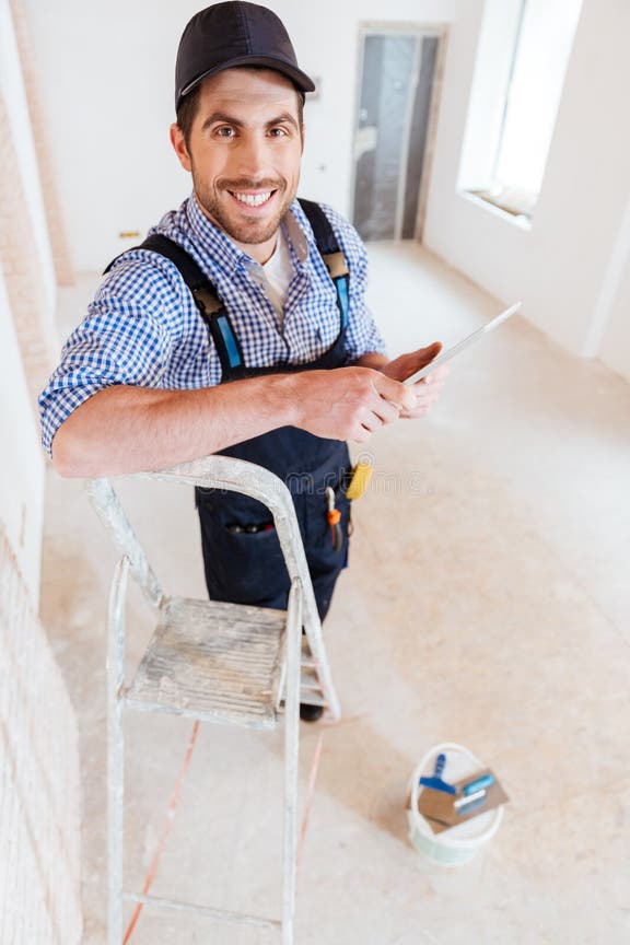 Smilling Handyman Using Pc Tablet Computer while Working Stock Photo ...