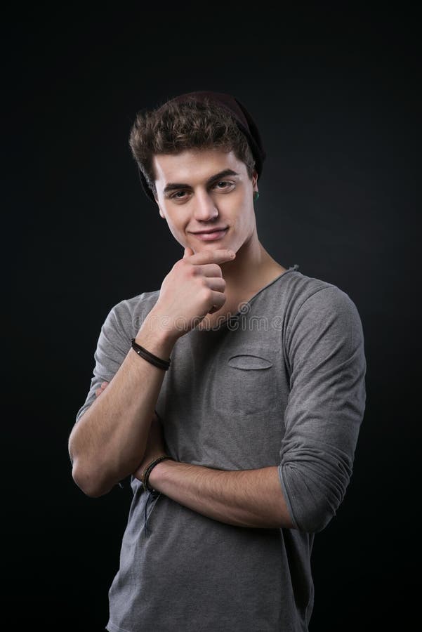 Smirking young man posing stock photo. Image of hand - 53129934