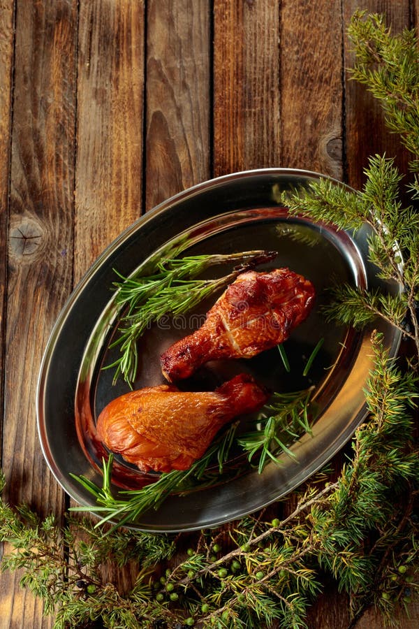 Smoked Chicken Drumsticks and Juniper Branches on a Wooden Table Stock ...