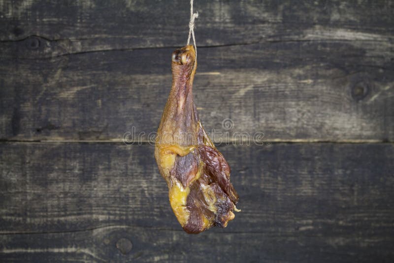 Smoked Chicken Leg Hanging on the Rope Against Wooden Background Stock ...