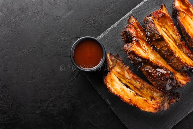 Smoked Pork Ribs and Barbecue Sauce Side View on Black Slate Board ...