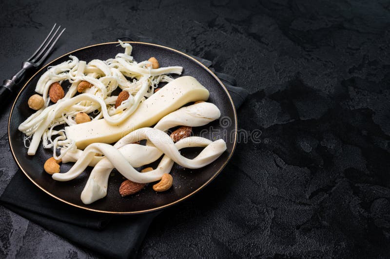 Smoked Traditional Chechil White Cheese on a Plate with Nuts, Black ...