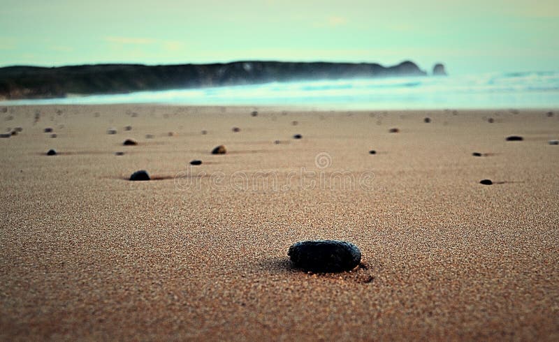 Smooth Black Stone on the Sand by the Ocean Stock Image - Image of ...