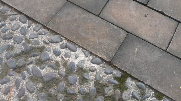 Smooth Gray Stones are Embedded in a Textured, Concrete-like Surface on ...
