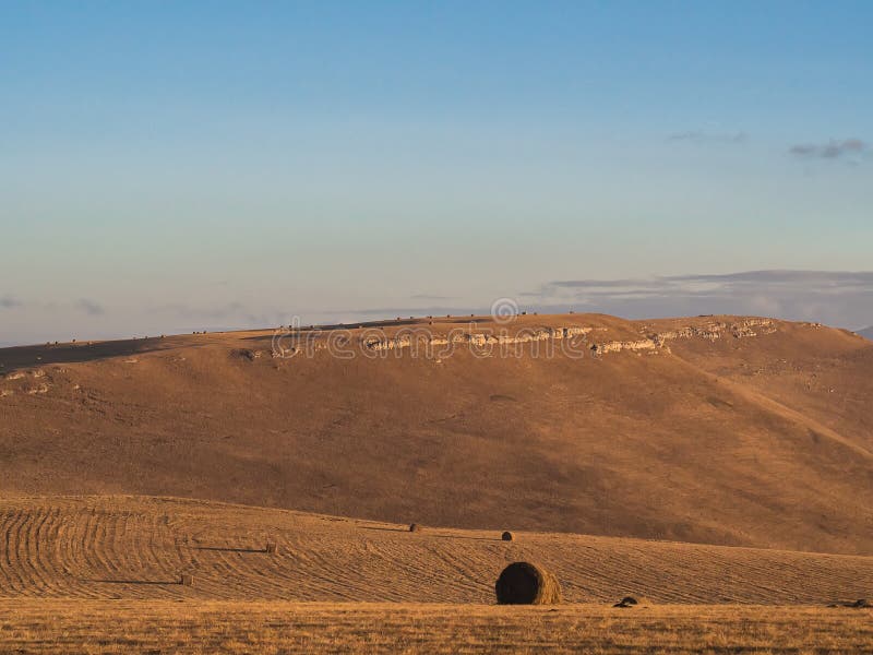 Smooth Mountain Peaks with Fields and Haystacks on Them Under a Blue ...