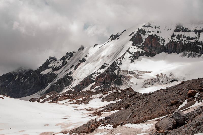 Smooth Mountain Side Covered in Snow Under Cloudy Sky Stock Photo ...