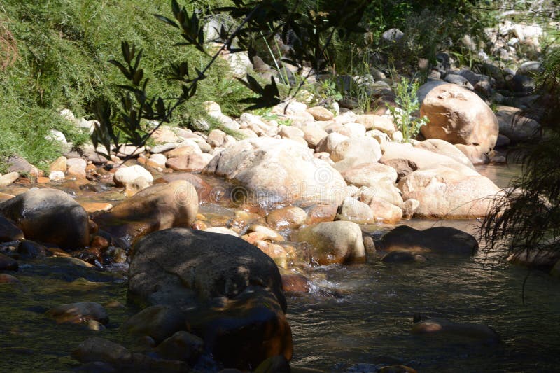 Smooth Rocks in a Riverbed with a Stream of Calming Waters. Stock Image ...