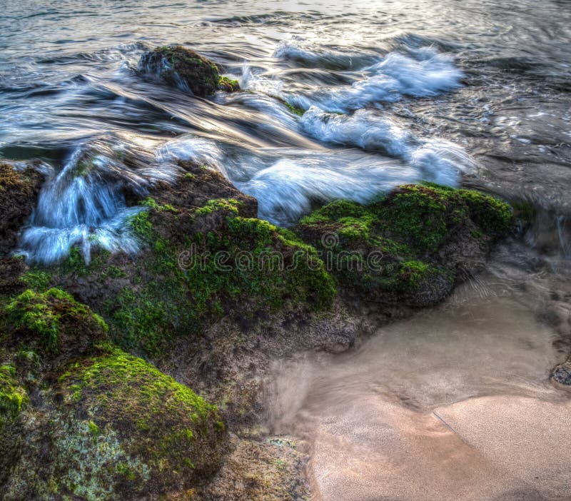 Smooth Waves Gently Wash Over Rocks at a Beach in Kauai Hawaii Stock ...