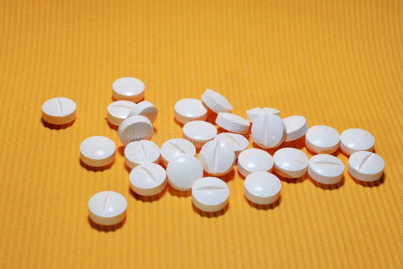 A Lot of White Smooth Convex Tablets with a Dividing Strip on a Pink ...