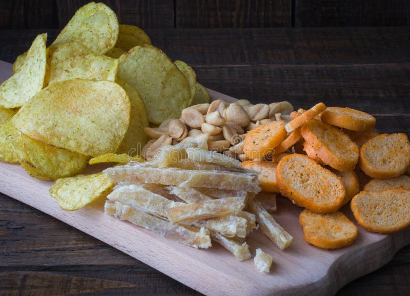 Snacks for Beer on the Table in the Pub. Peanuts, Pieces of Fish ...