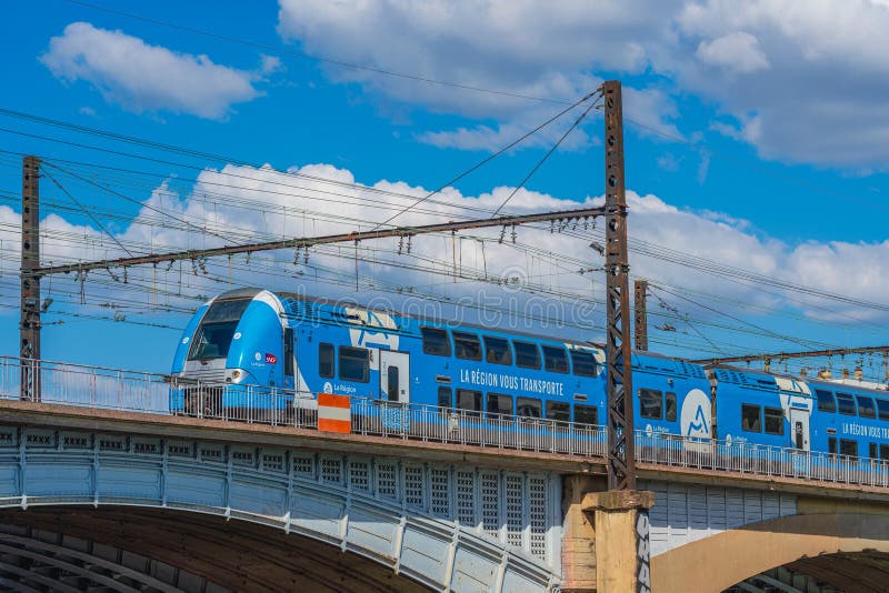 A SNCF Blue Train Crosses a Bridge Under a Clear Sky during the Day ...