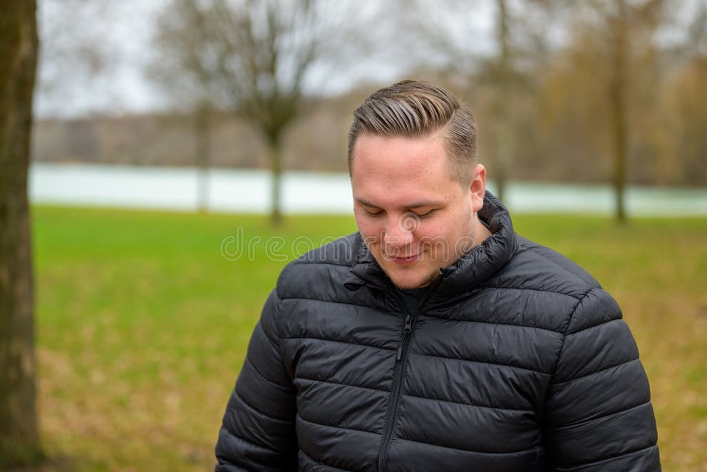 Sniggering Young Man Looking Down with a Smile Stock Photo - Image of ...