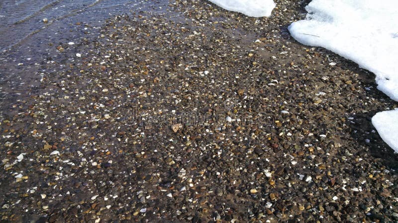 Snow on beach of pebbles stock image. Image of melting - 51508371