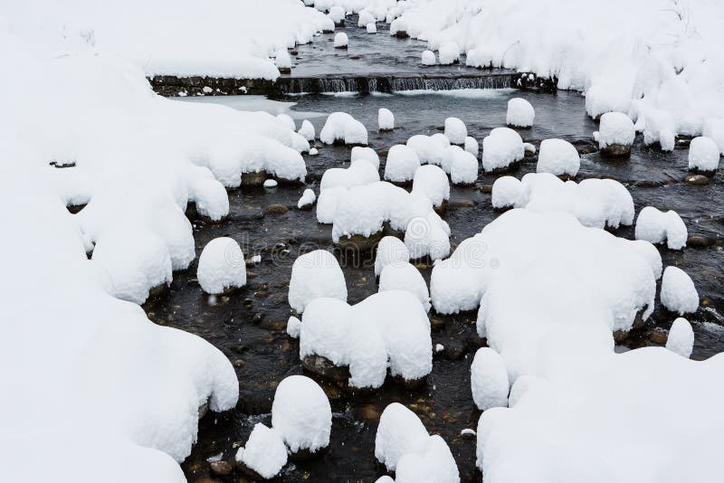 Snow Caps on Boulders in the Mountain River Stock Photo - Image of ...
