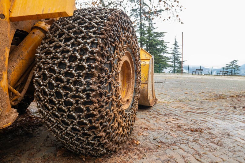 Snow Chains on a Construction Machine, Yellow Construction Machine with ...