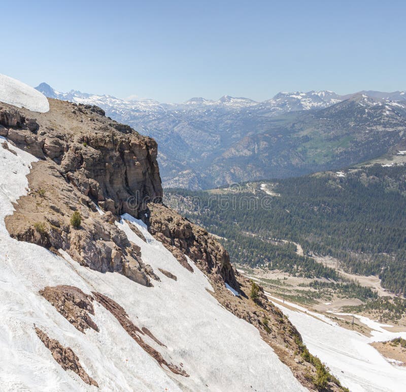 Snow-covered Cliff Towards a Valley with Mountains in the Background ...