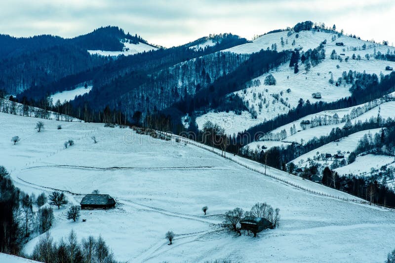 Snow-covered Hills with Scattered Cabins in a Serene Winter Landscape ...