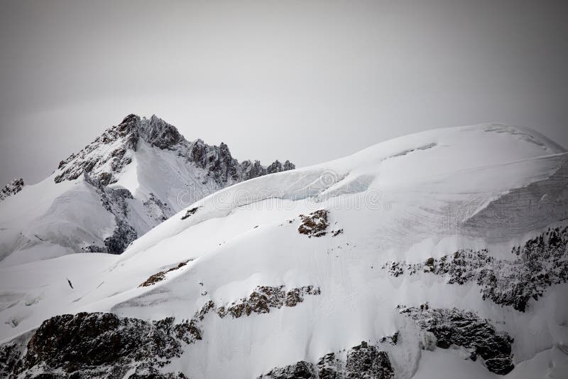 Snow-covered Mountain Range with Low-hanging Clouds Editorial ...