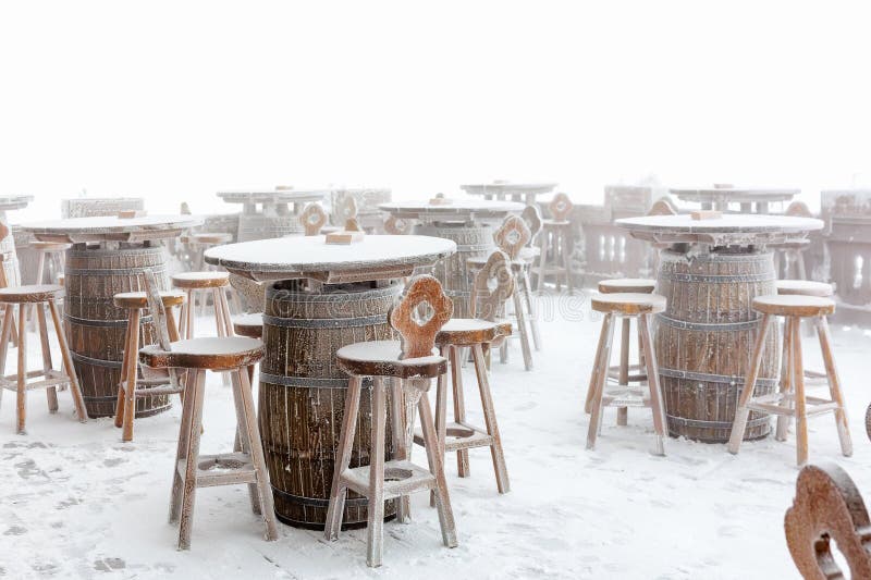 Snow-covered Outdoor Bar Area with Barrel Tables and Stools Stock Image ...