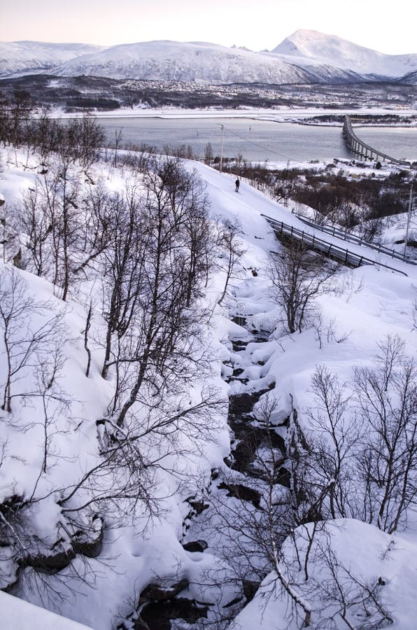 Snow Covered Path with Bridge and Mountains in the Background Stock ...