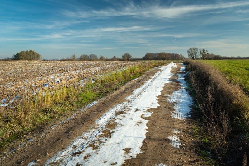 Snow on a Dirt Road through Fields, Horizon and Clouds on a Blue Sky in ...