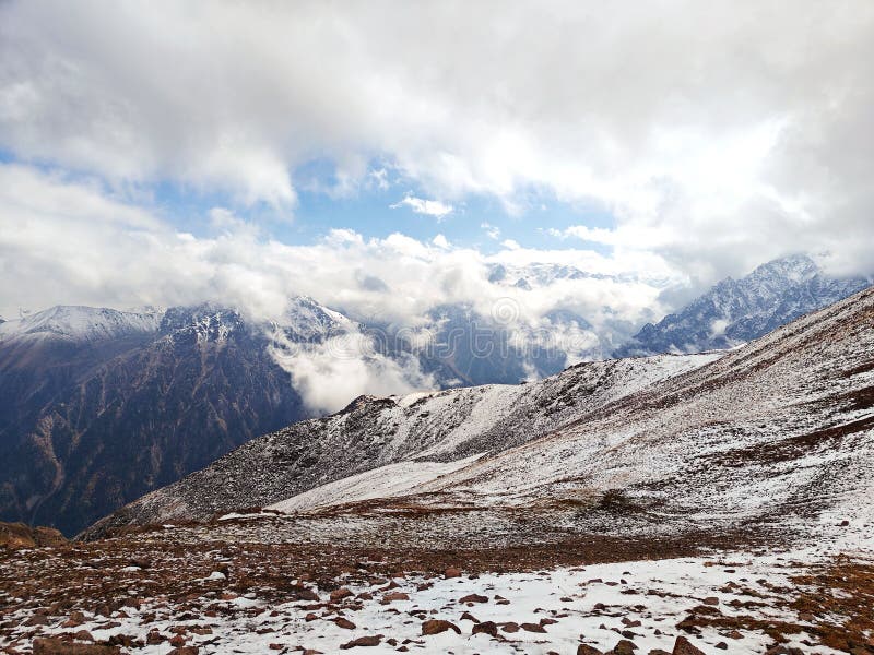 Snow-dusted Mountain Ridge with Rugged Terrain Under a Cloudy Sky Stock ...