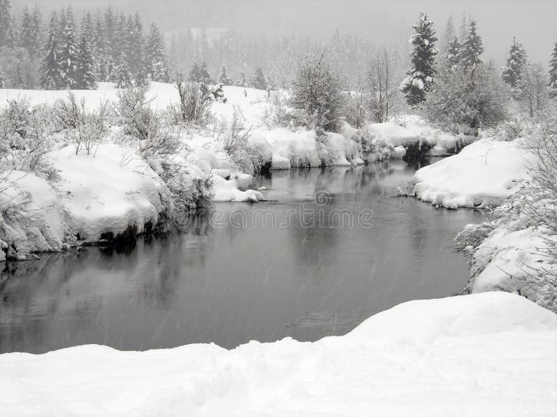 Snow Falling on a River with Snowy Banks in Whistl Stock Image - Image ...